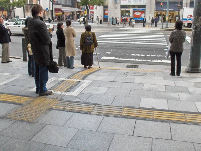 Photo shows sidewalk with a strip about a foot wide extending along the ...