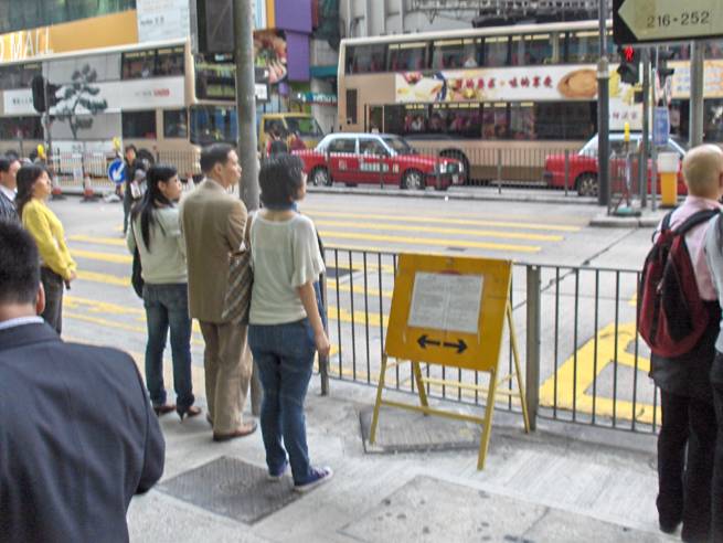 4 photos show an intersection with a railing extending along the curb ...