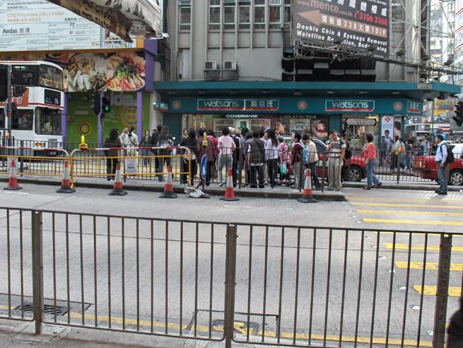 4 photos show an intersection with a railing extending along the curb ...